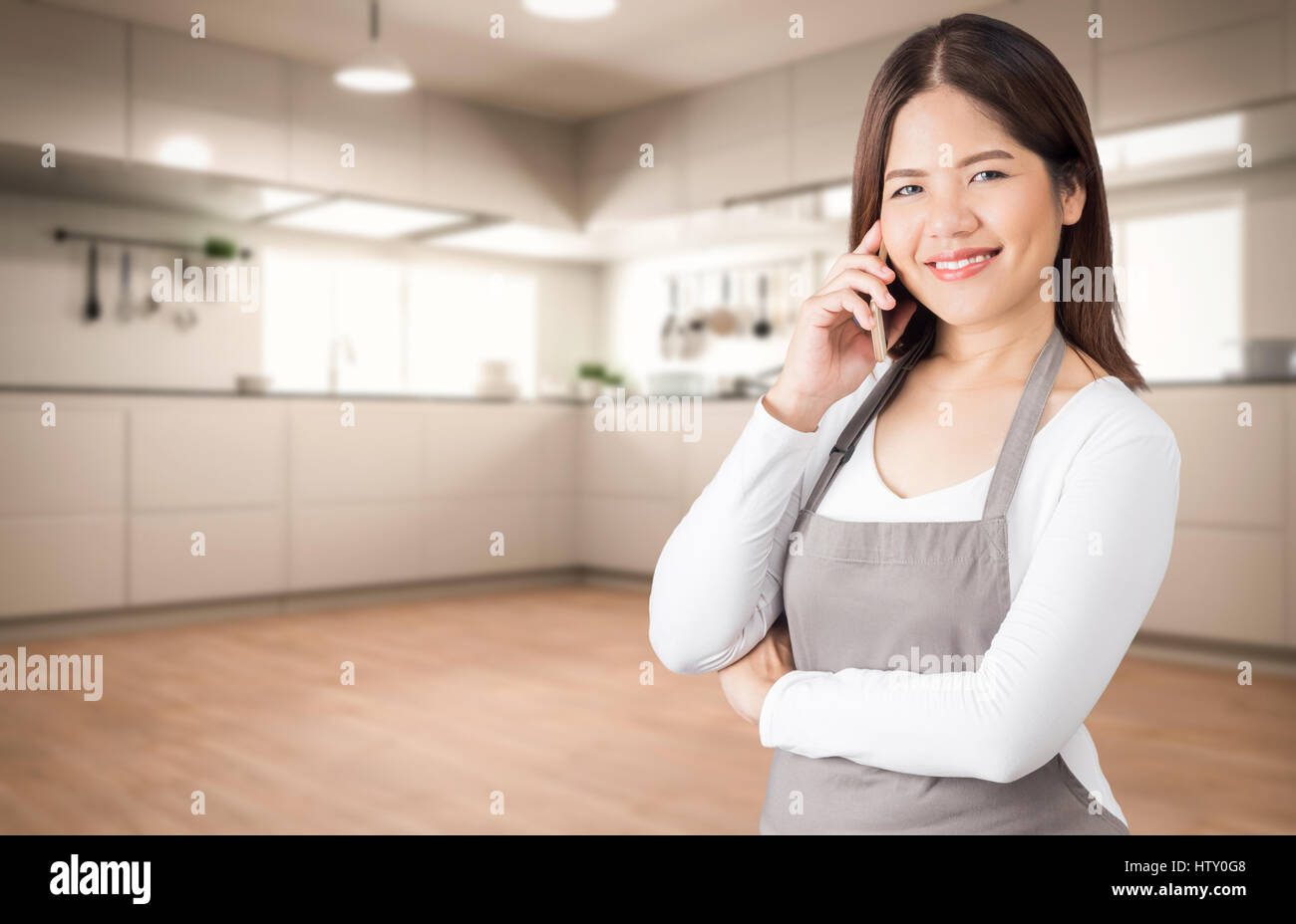 asian housekeeper with kitchen background Stock Photo - Alamy