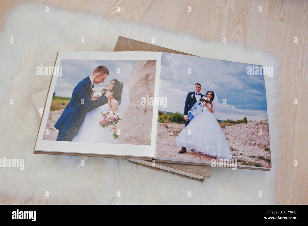 Pages of wedding photobook or wedding album at carpet on wooden ...
