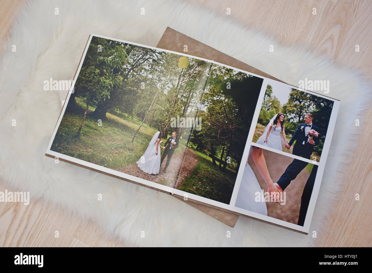 Pages of wedding photobook or wedding album at carpet on wooden ...