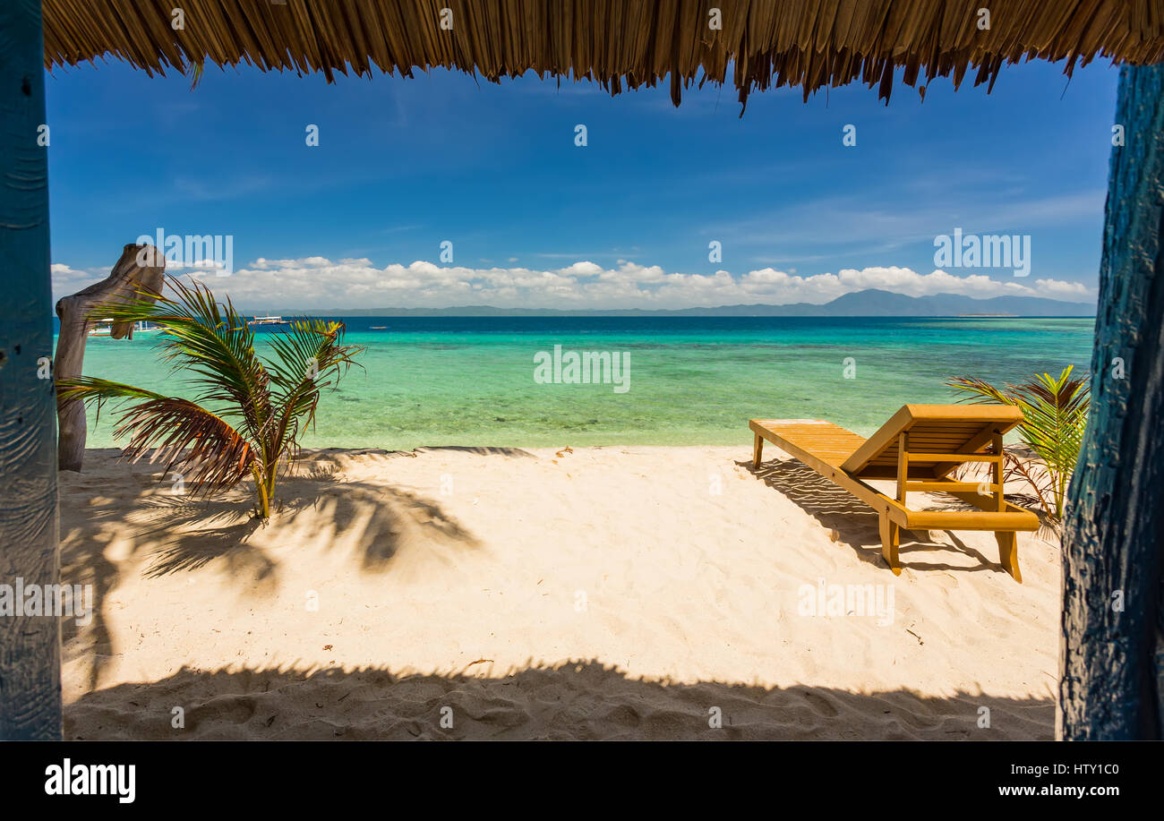 Window view from beautiful beach resort with palm trees and clear water ...