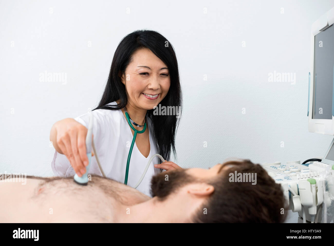 Doctor Performing Ultrasound Treatment On Patient Stock Photo - Alamy