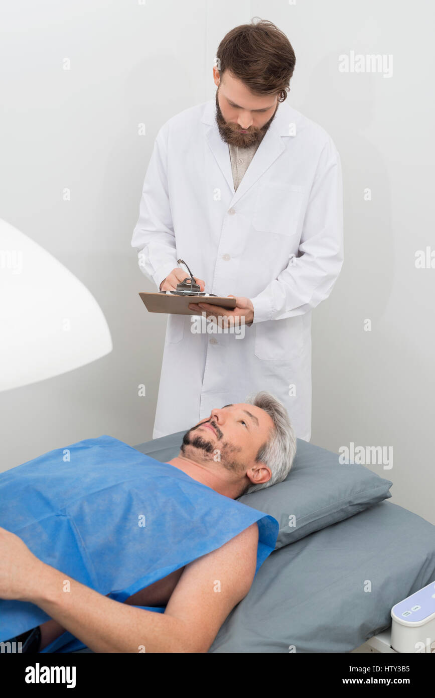 Doctor writing on medical chart hi-res stock photography and images - Alamy