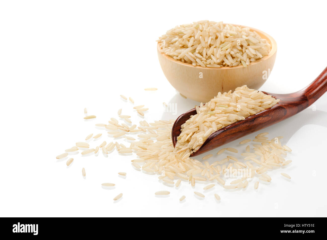 brown rice on wooden spoon over white background Stock Photo - Alamy