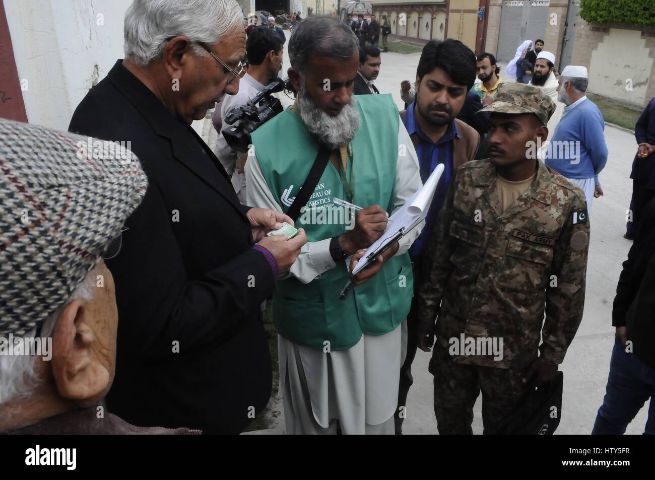 Attock, Pakistan. 14th Mar, 2017. An official from the Pakistan Bureau of Statistics marks a ...