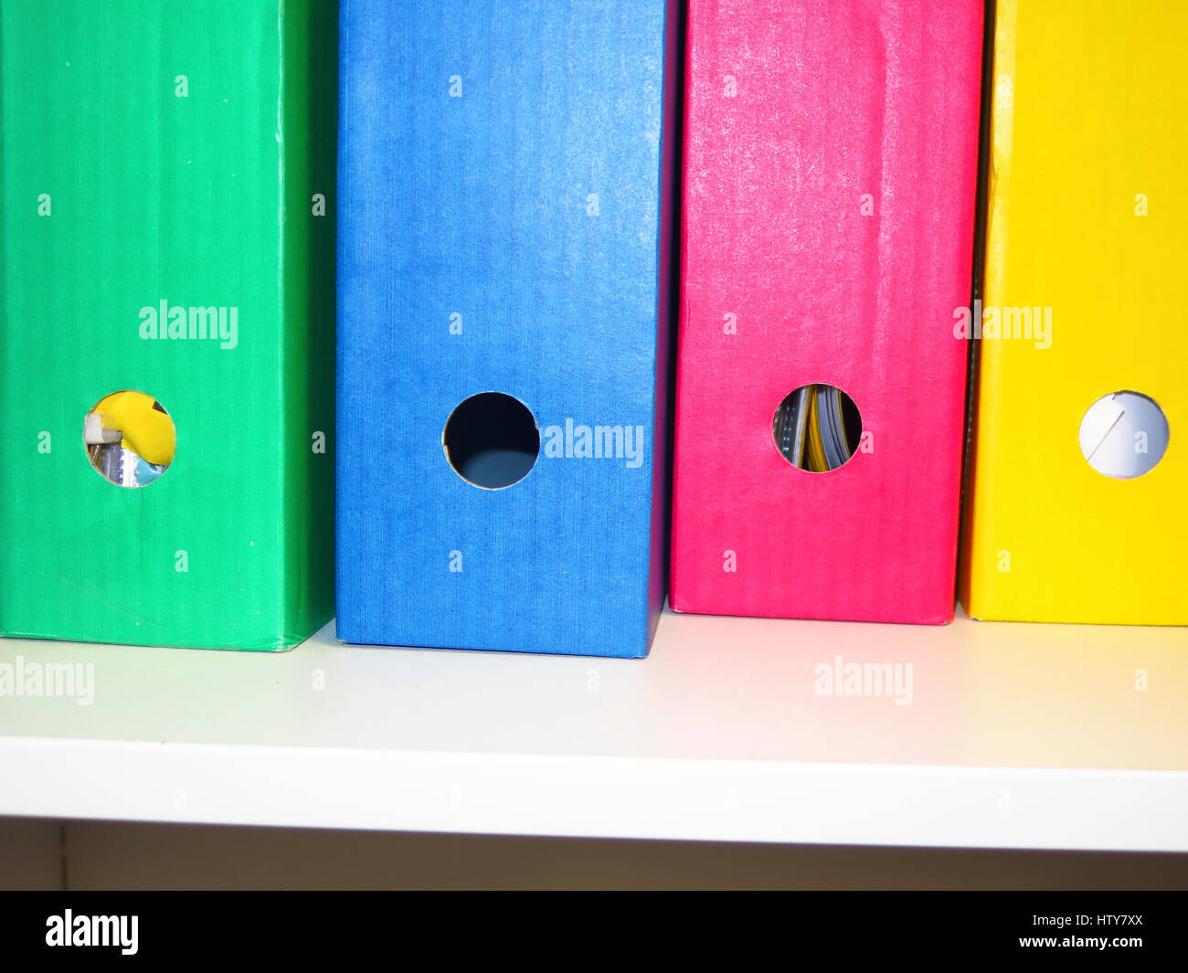 Coloured binders on shelf Stock Photo - Alamy