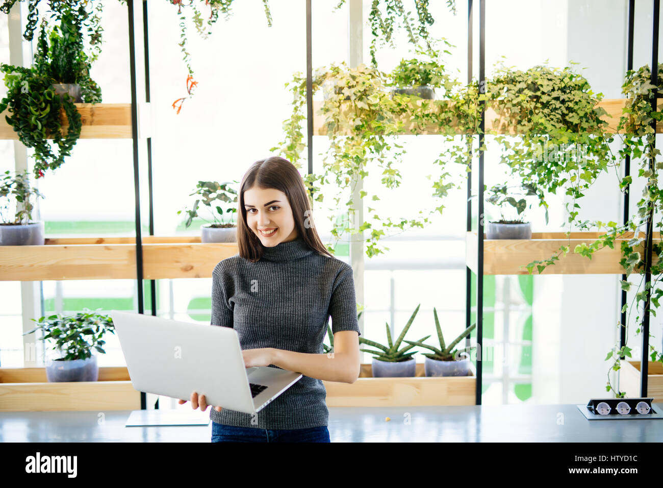 Waist up portrait of serious young businesswoman holding laptop ...