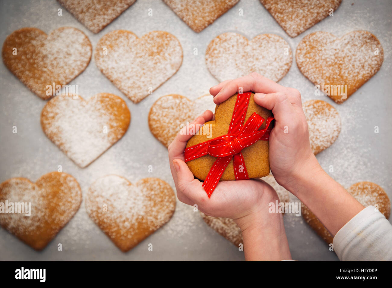 Girl's Hands holding heart shaped cookies Stock Photo - Alamy