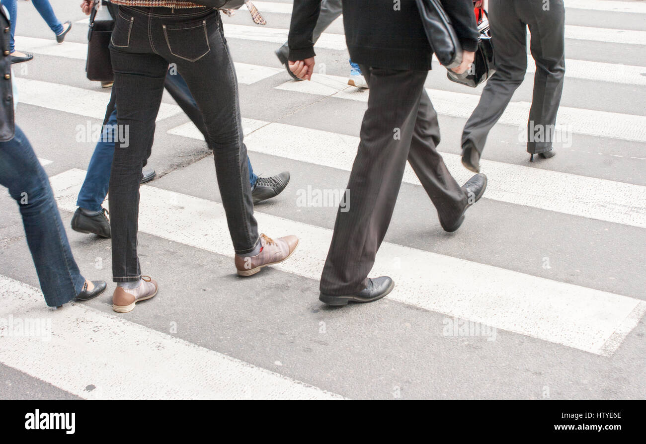 Men and women walking across a pedestrian crossing Stock Photo - Alamy