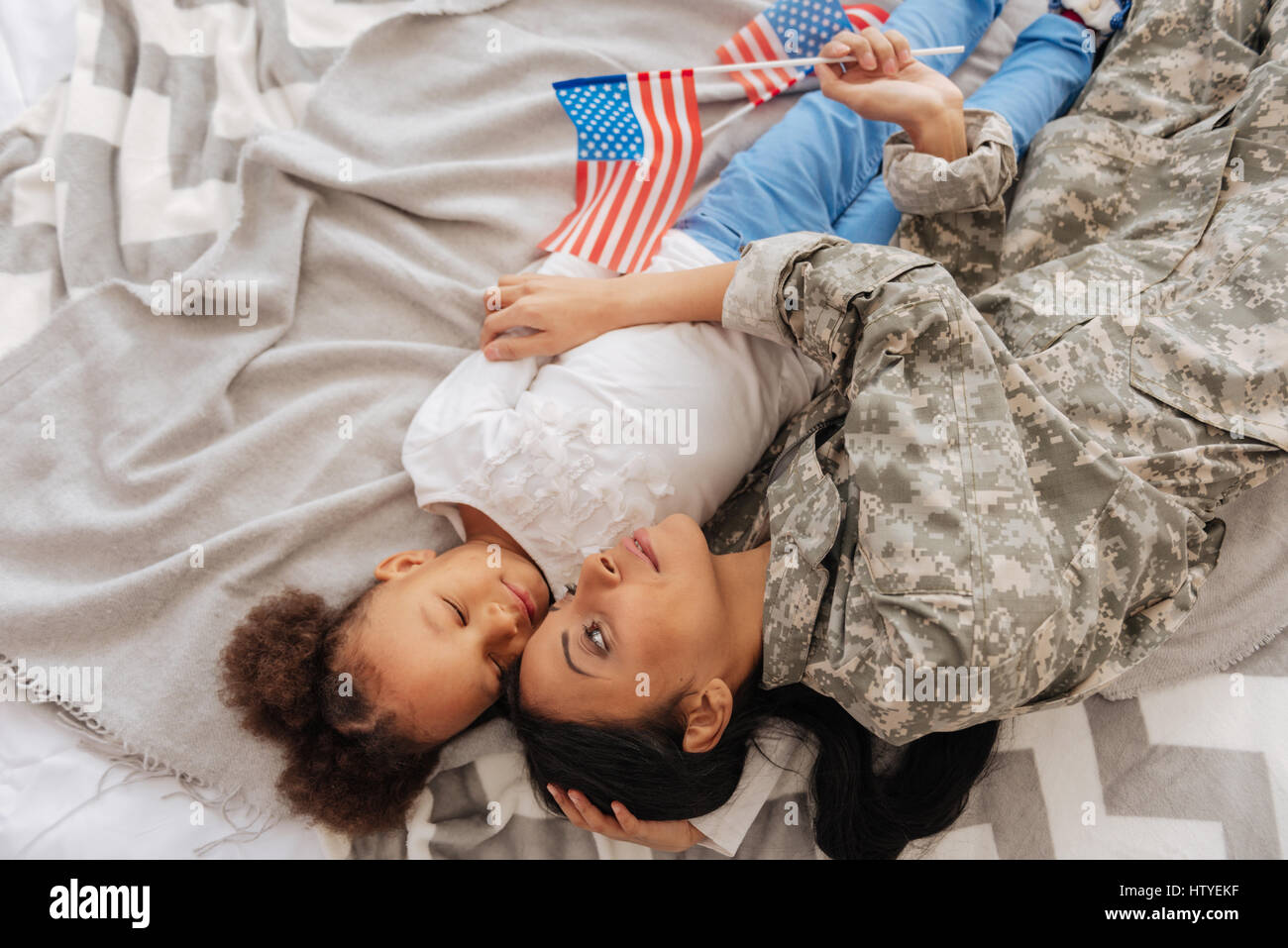 Pretty attached child and her mom resting in bed Stock Photo - Alamy