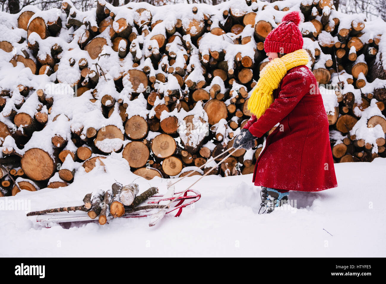 Girl pulling a sledge with firewood Stock Photo - Alamy