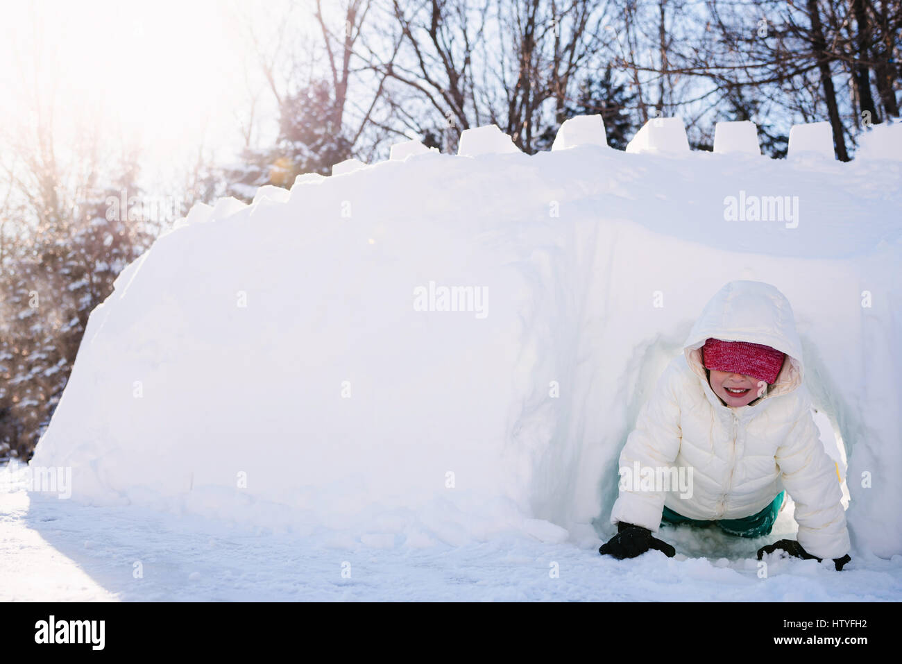 Girl playing in a snow fort Stock Photo - Alamy