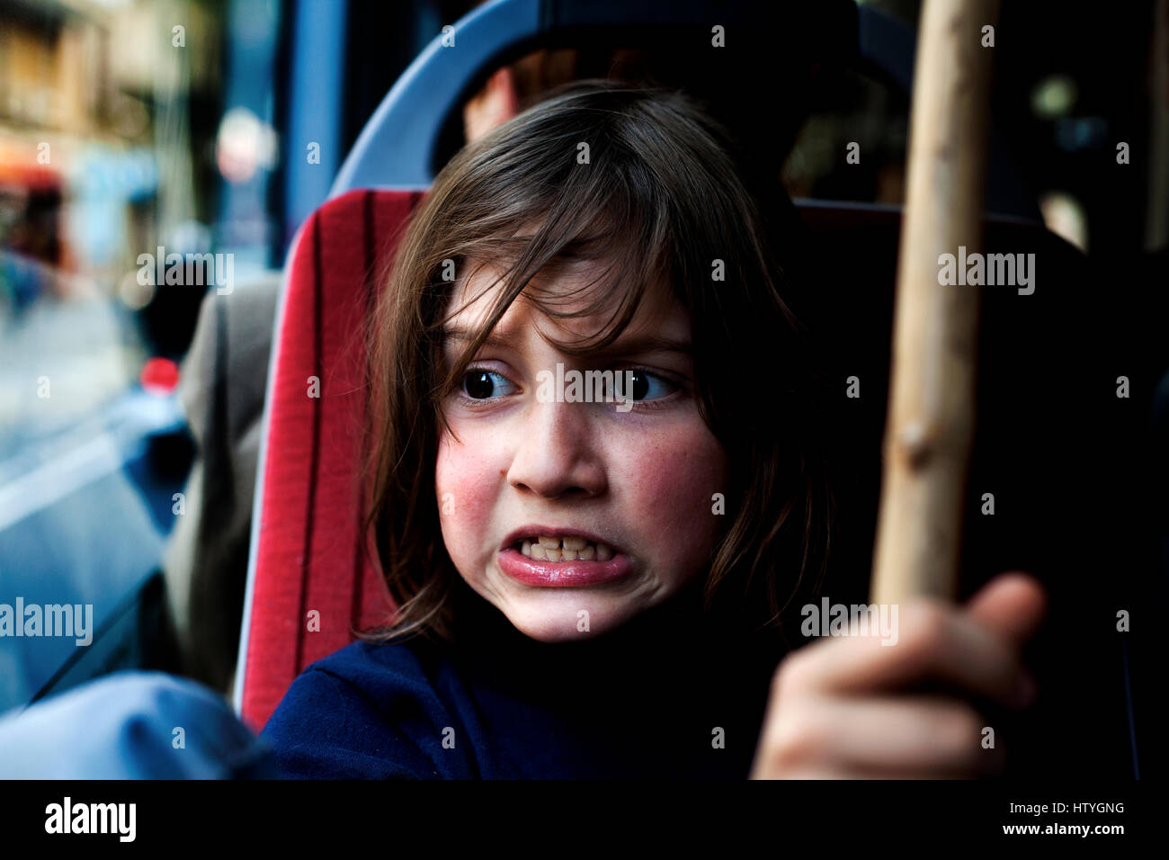 8 year old boy making an angry face whilst on the bus in Barcelona ...