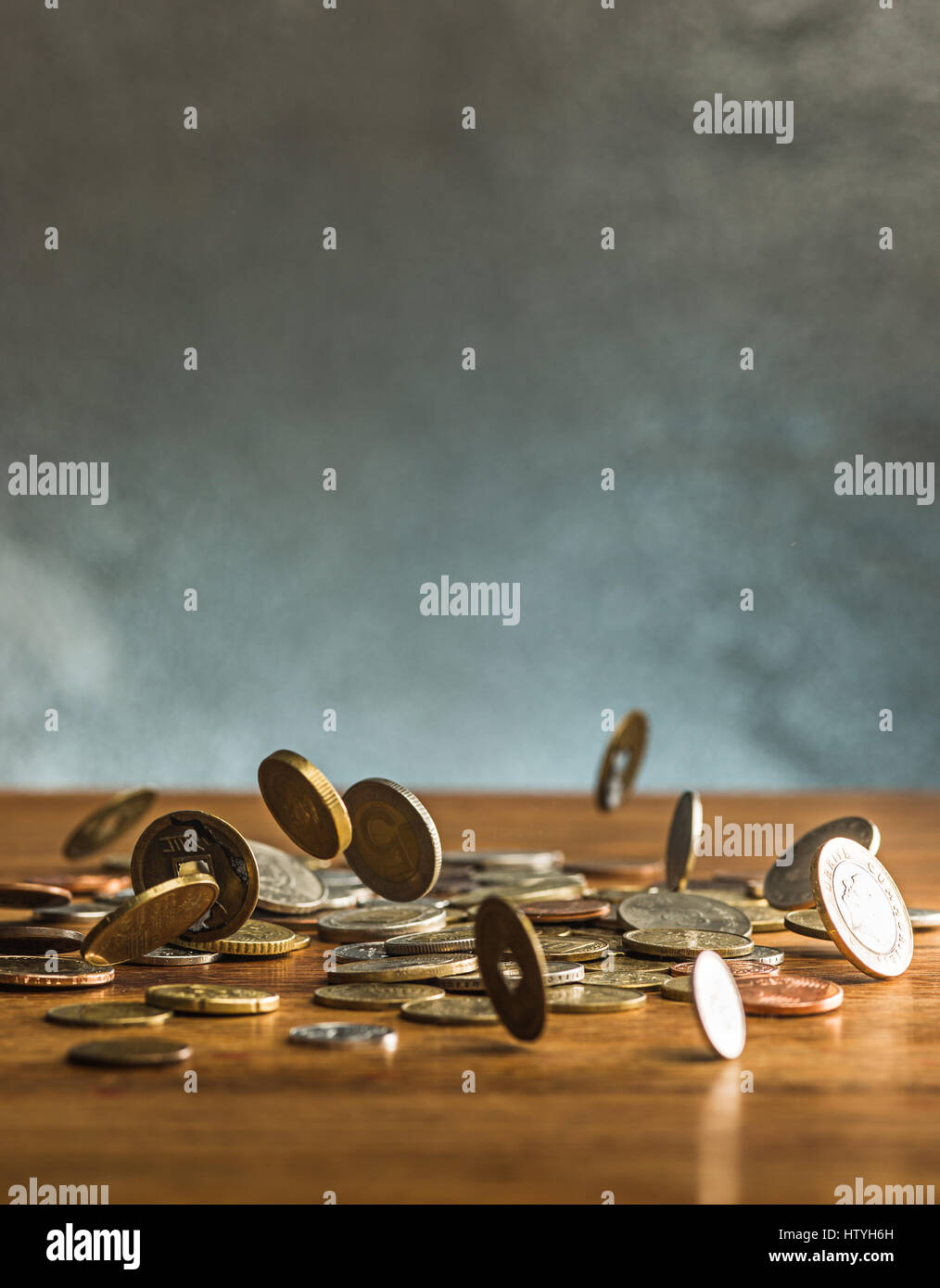 The silver and golden coins and falling coins on wooden table ...