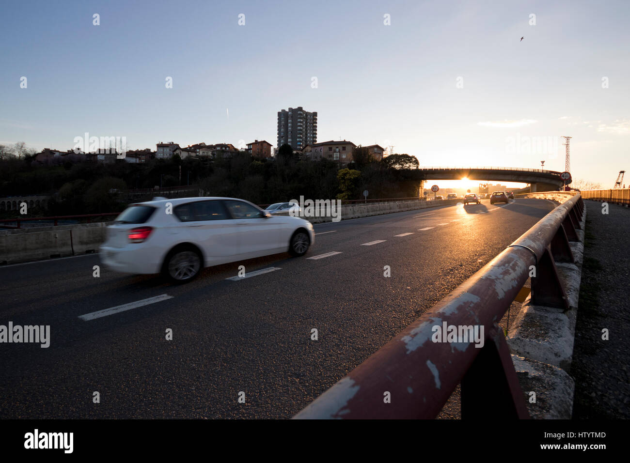 Wide angle view of a white car moving on a highway at sunset in ...