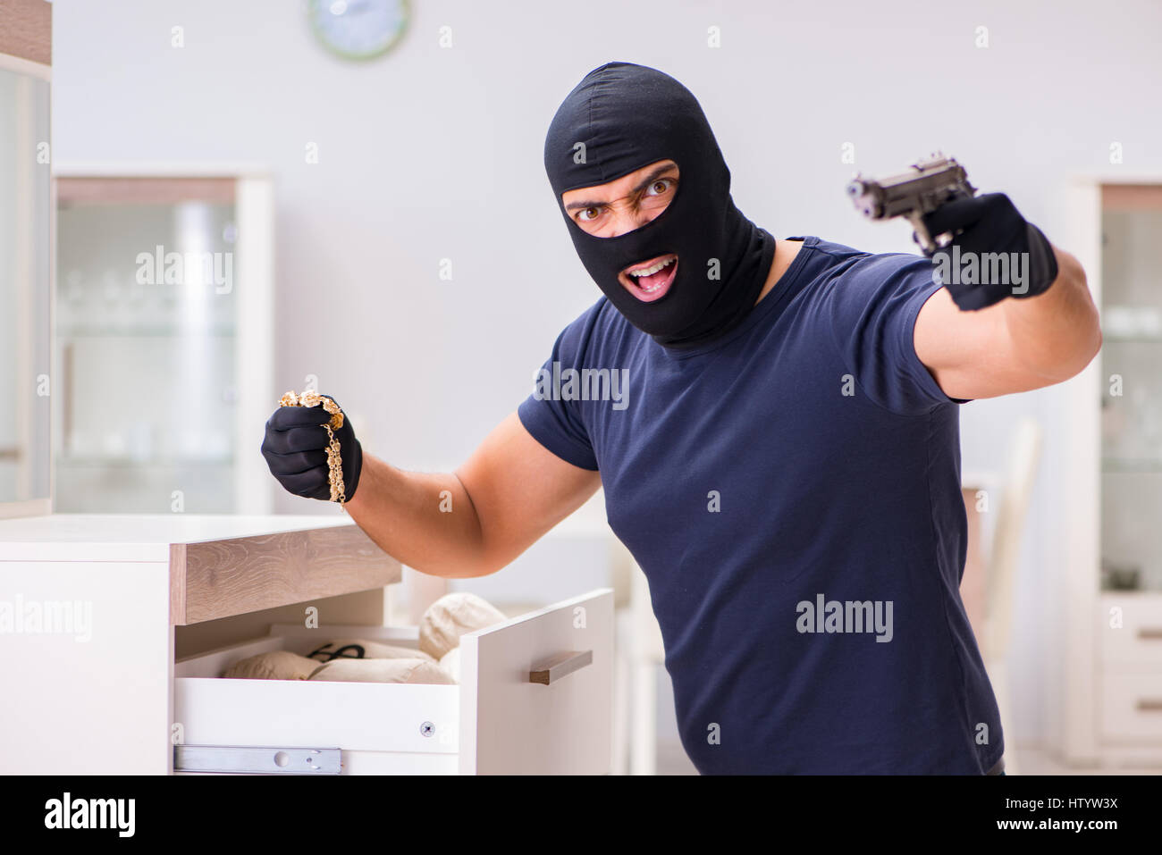 Robber wearing balaclava stealing valuable things Stock Photo - Alamy