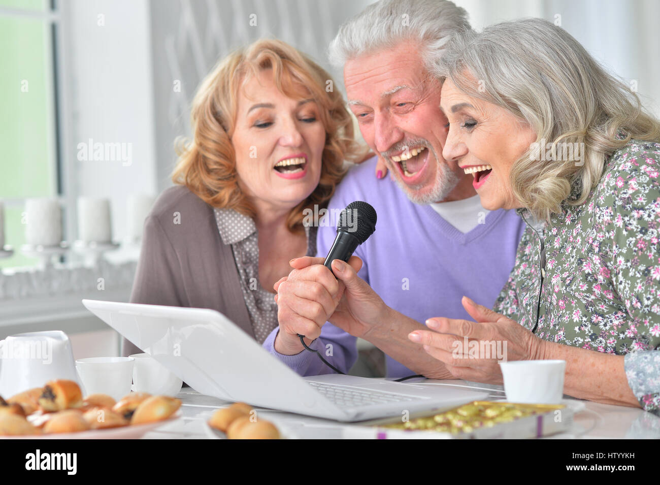 Elderly people singing karaoke Stock Photo - Alamy