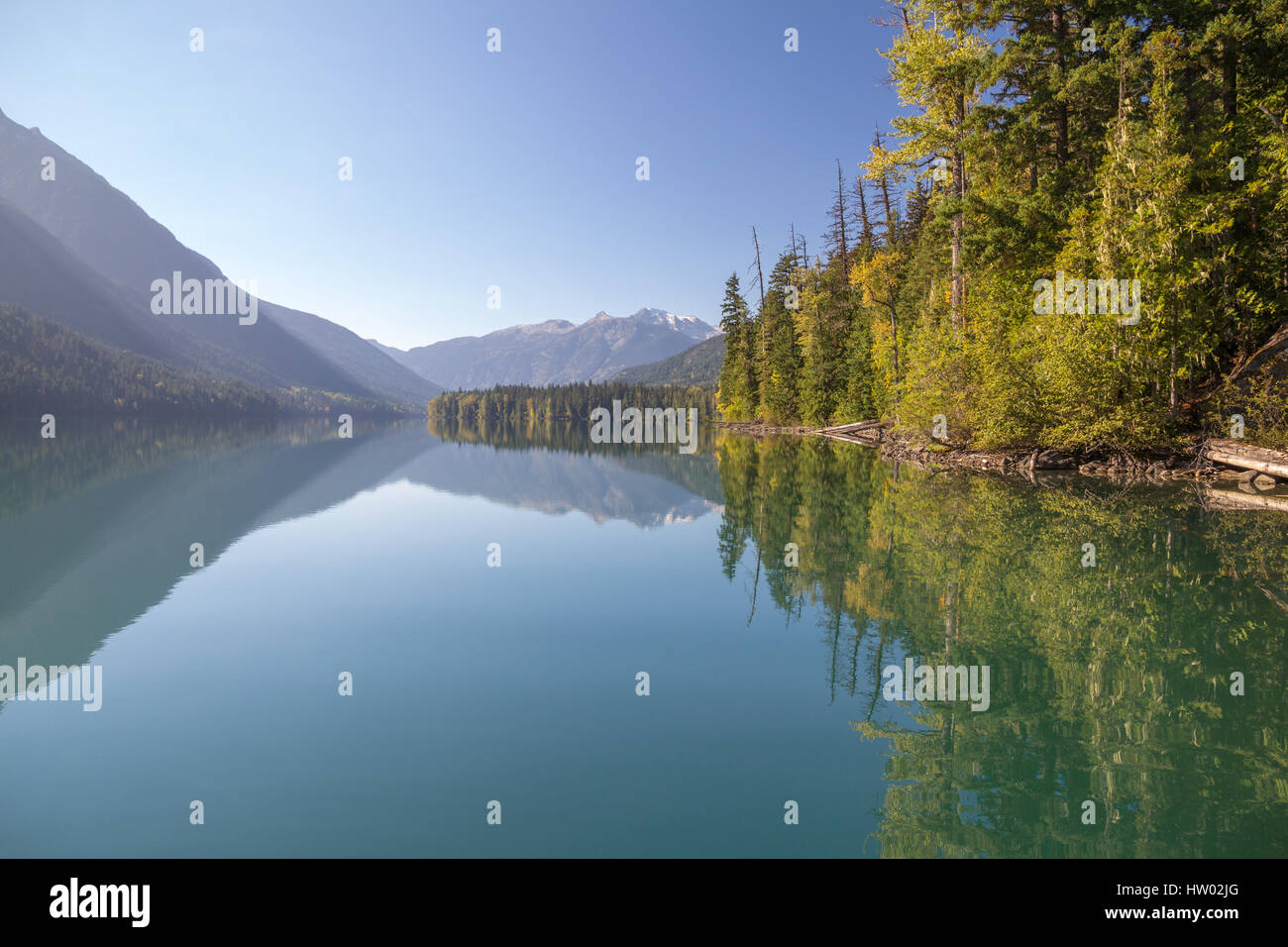 Blue skies, mountains and shoreline reflect perfectly, Birkenhead Lake ...