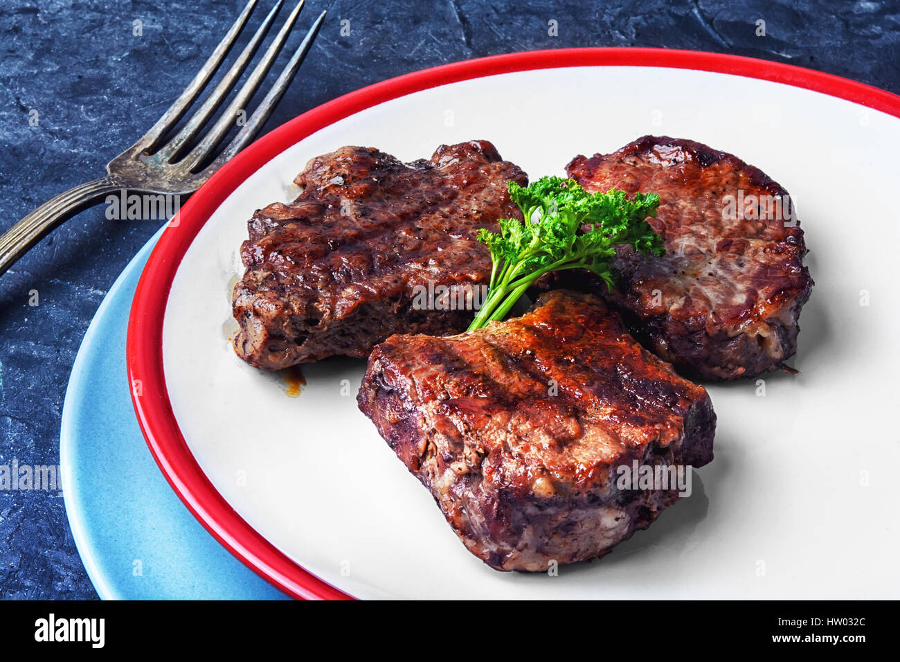 Three grilled steak of beef on the plate Stock Photo - Alamy
