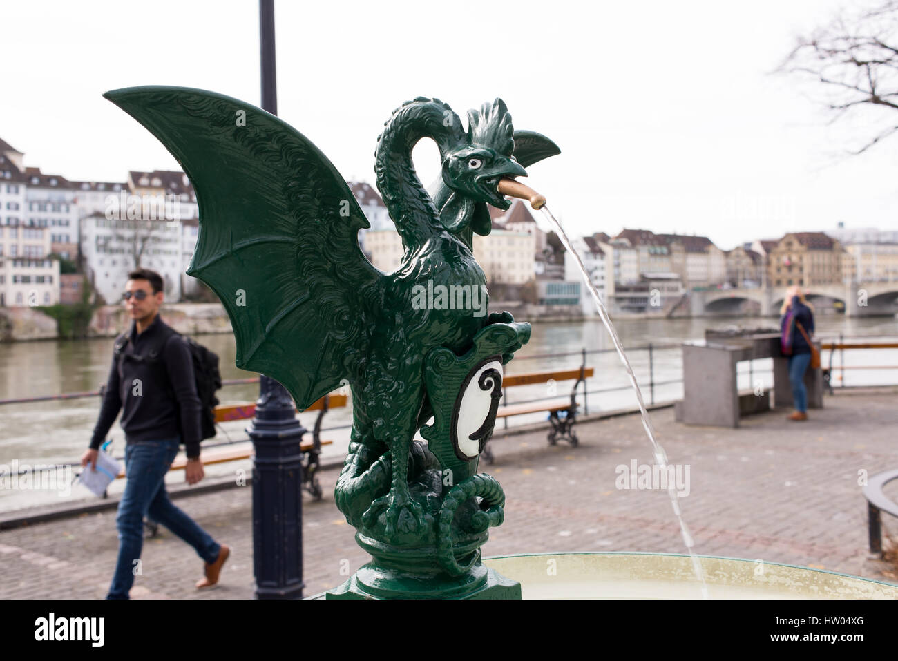 Dragon water fountain on Basel river front with people, river Rhine and ...