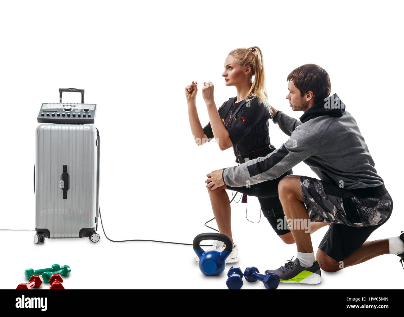 Blonde EMS fitness woman in full electrical muscular stimulation suit ...