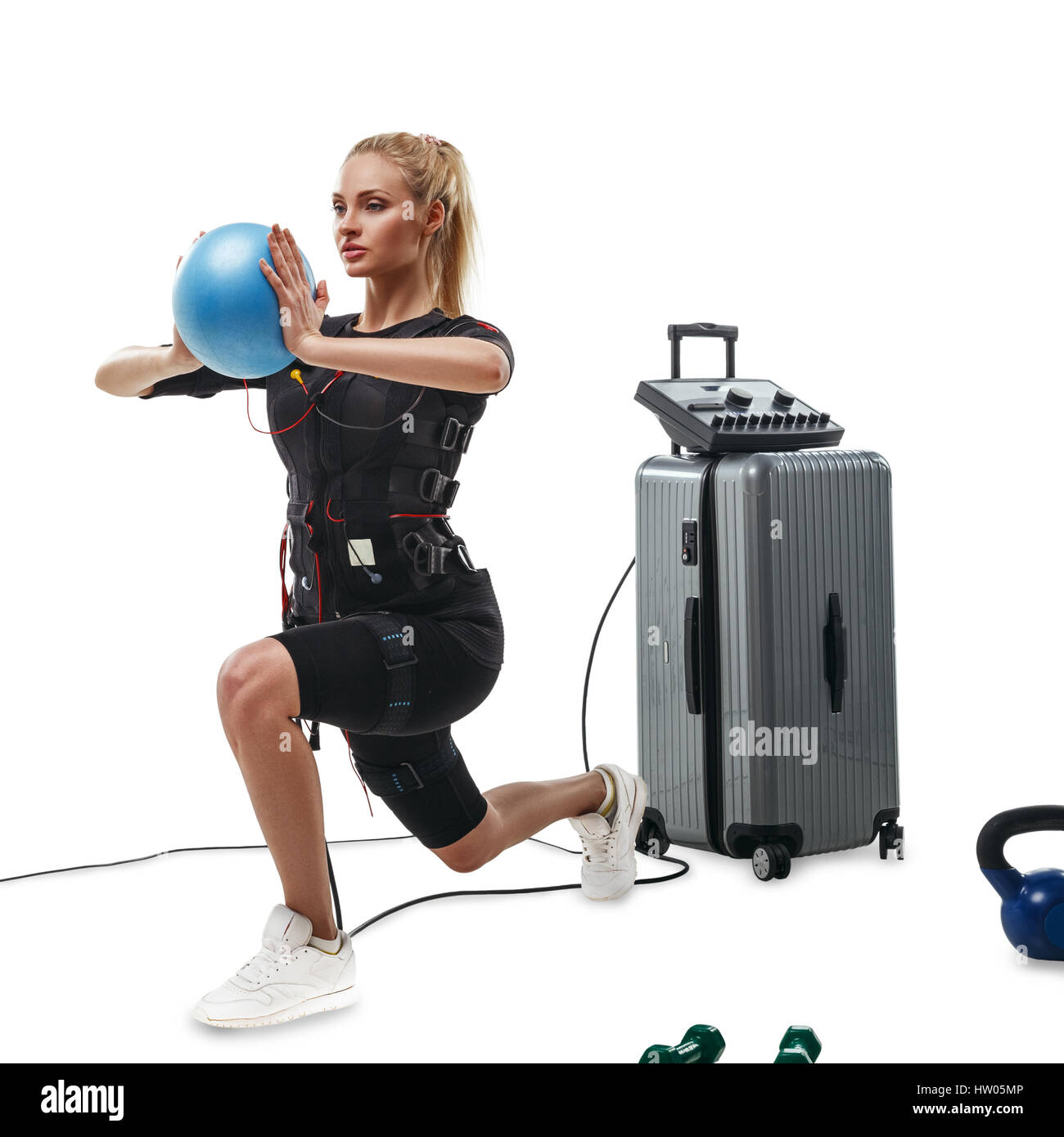 Blonde EMS fitness woman in full electrical muscular stimulation suit ...