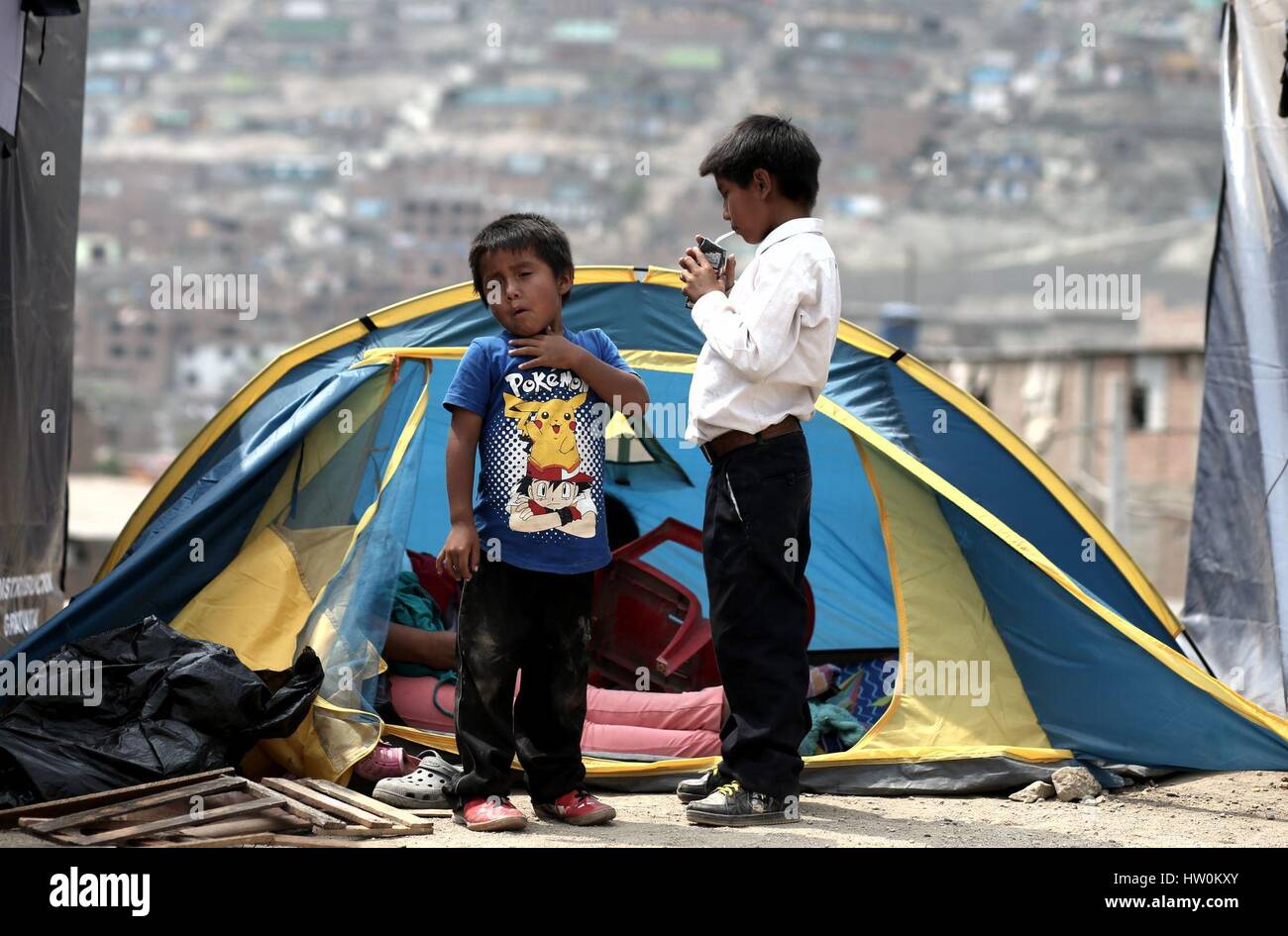 Lima, Peru. 22nd Mar, 2017. Children stand beside a camp in Lurigancho ...