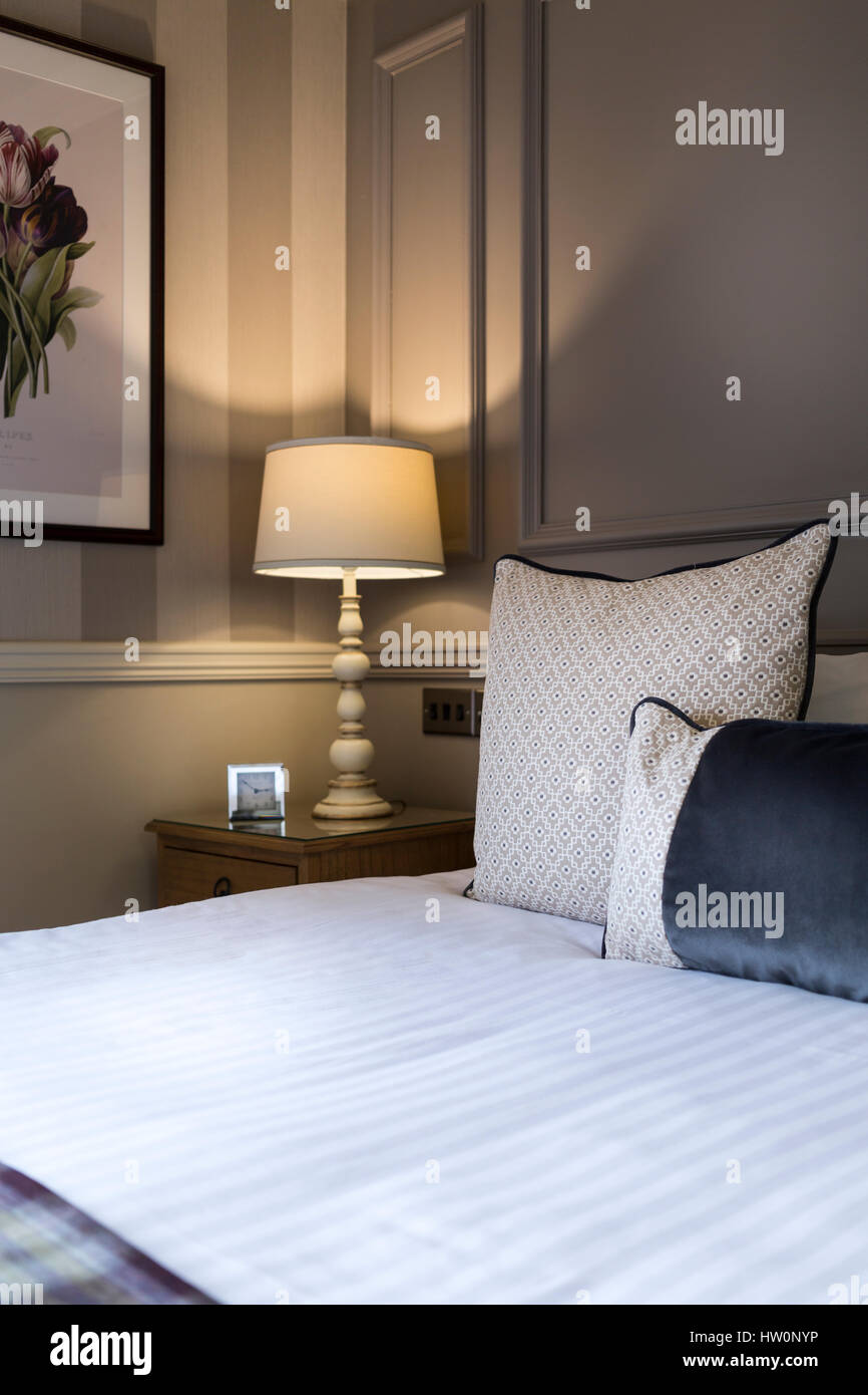 Hotel bed with side table and light Stock Photo - Alamy