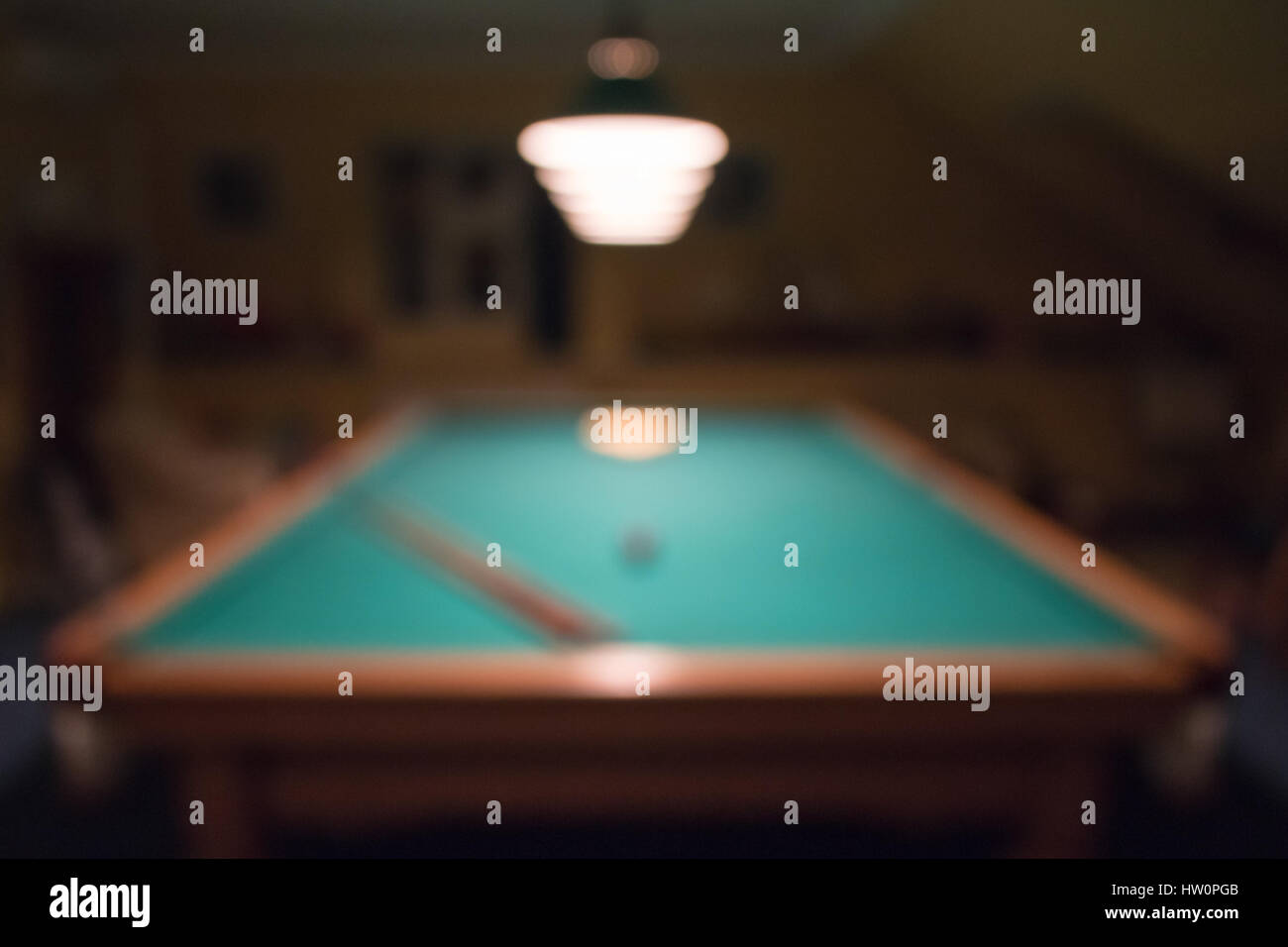 Abstract blur. Billiard table with balls and cues in the light of lamps ...