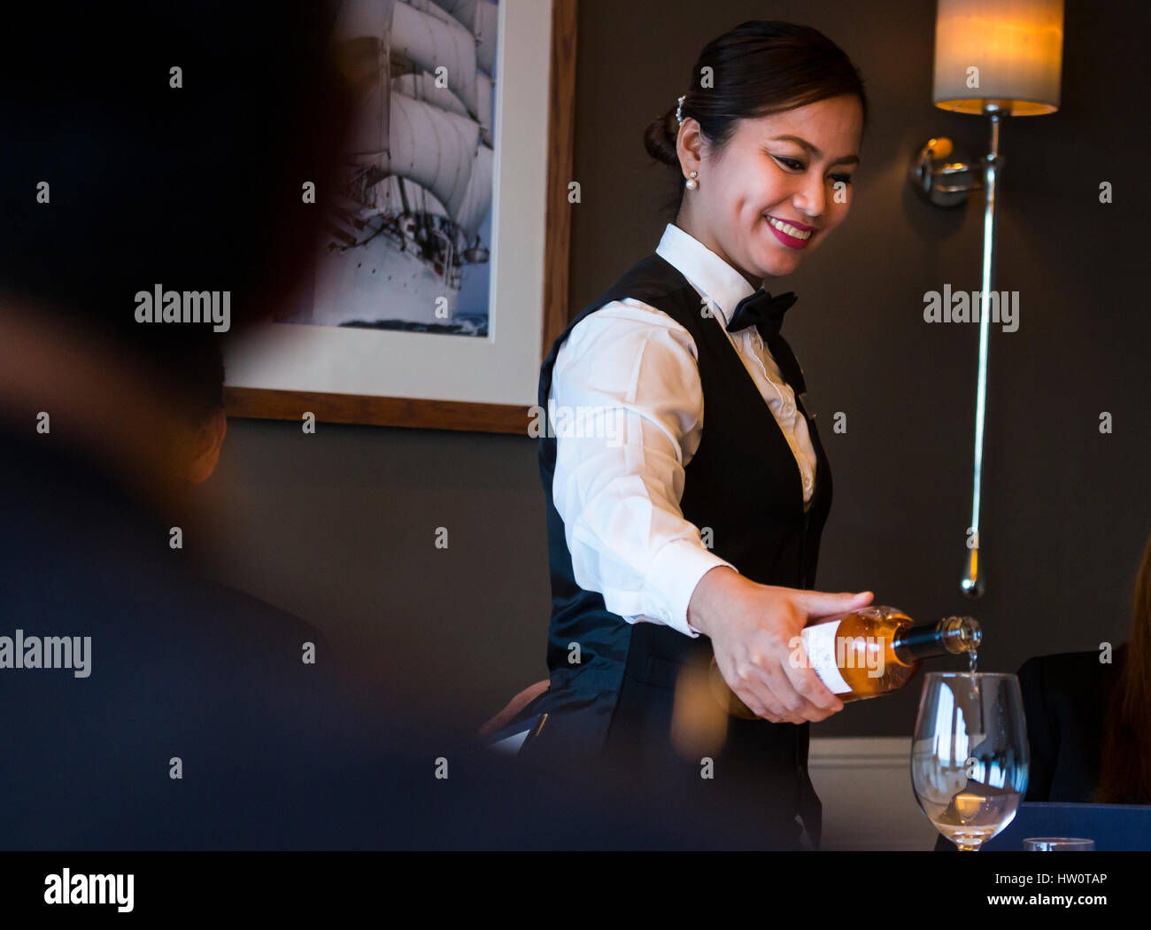 Formal Waitress poring wine Stock Photo - Alamy