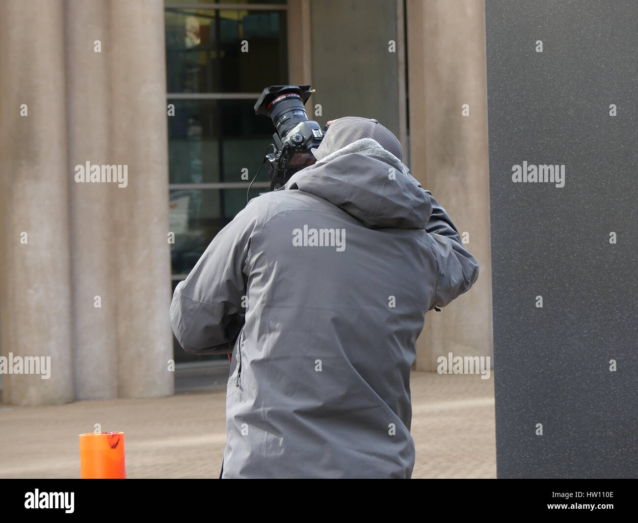 Man working camera outdoor building background Stock Photo - Alamy