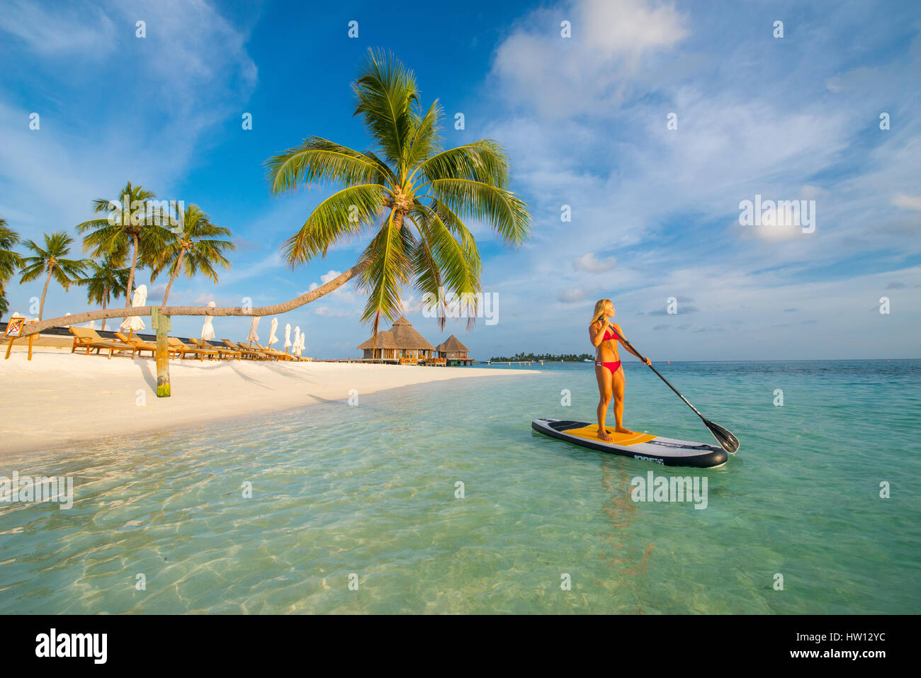 Maldives, Rangali Island. Conrad Hilton Resort. Woman on a paddleboard ...