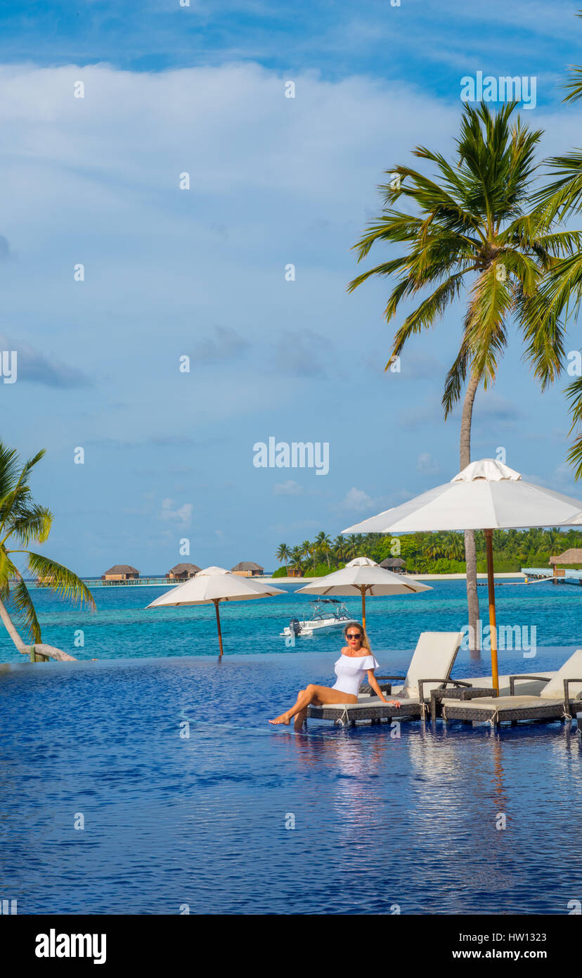 Maldives, Rangali Island. Conrad Hilton Resort. Woman relaxing at the ...