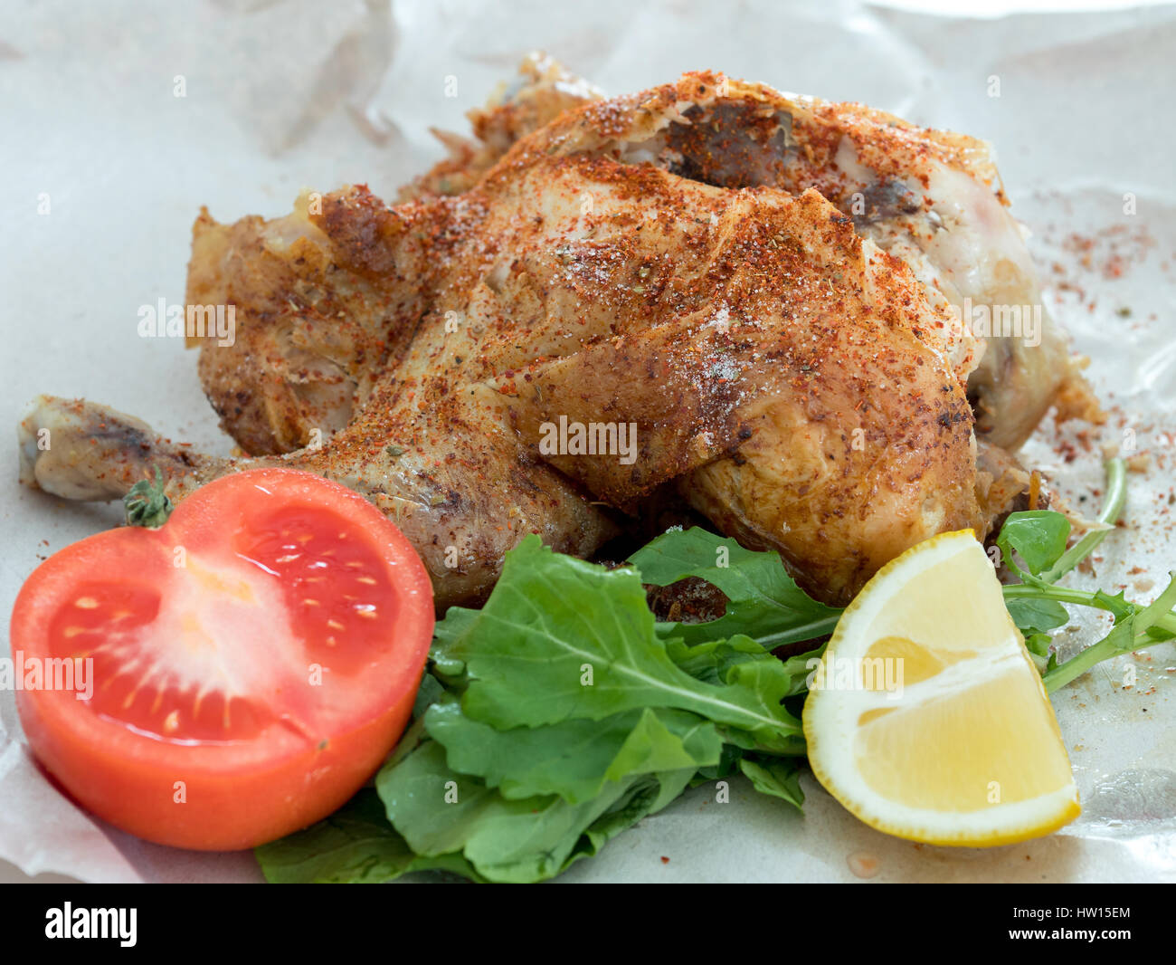 Whole roast grilled chicken with veggies on a paper Stock Photo - Alamy