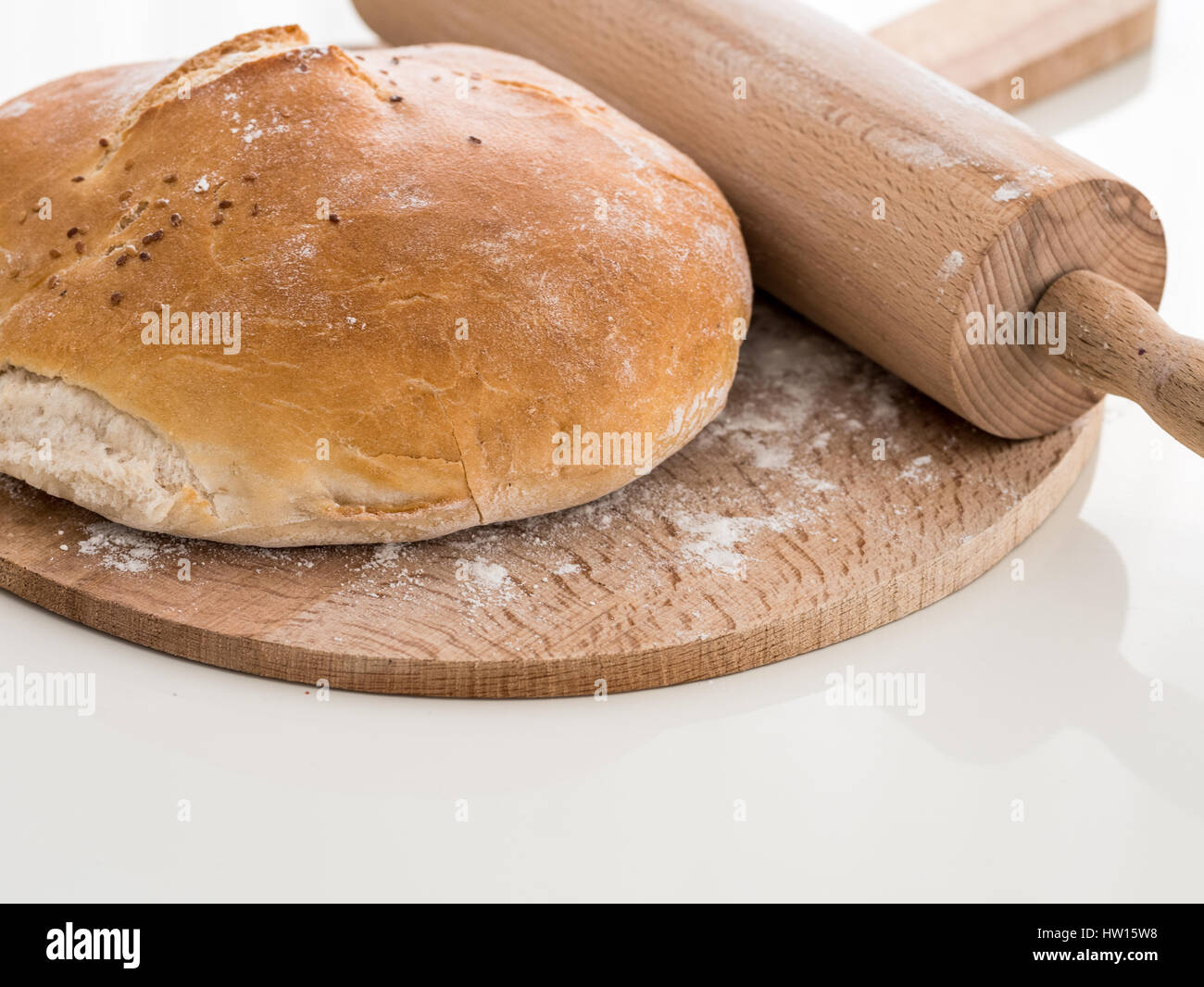 Round bun bread with a rolling pin on white table Stock Photo - Alamy