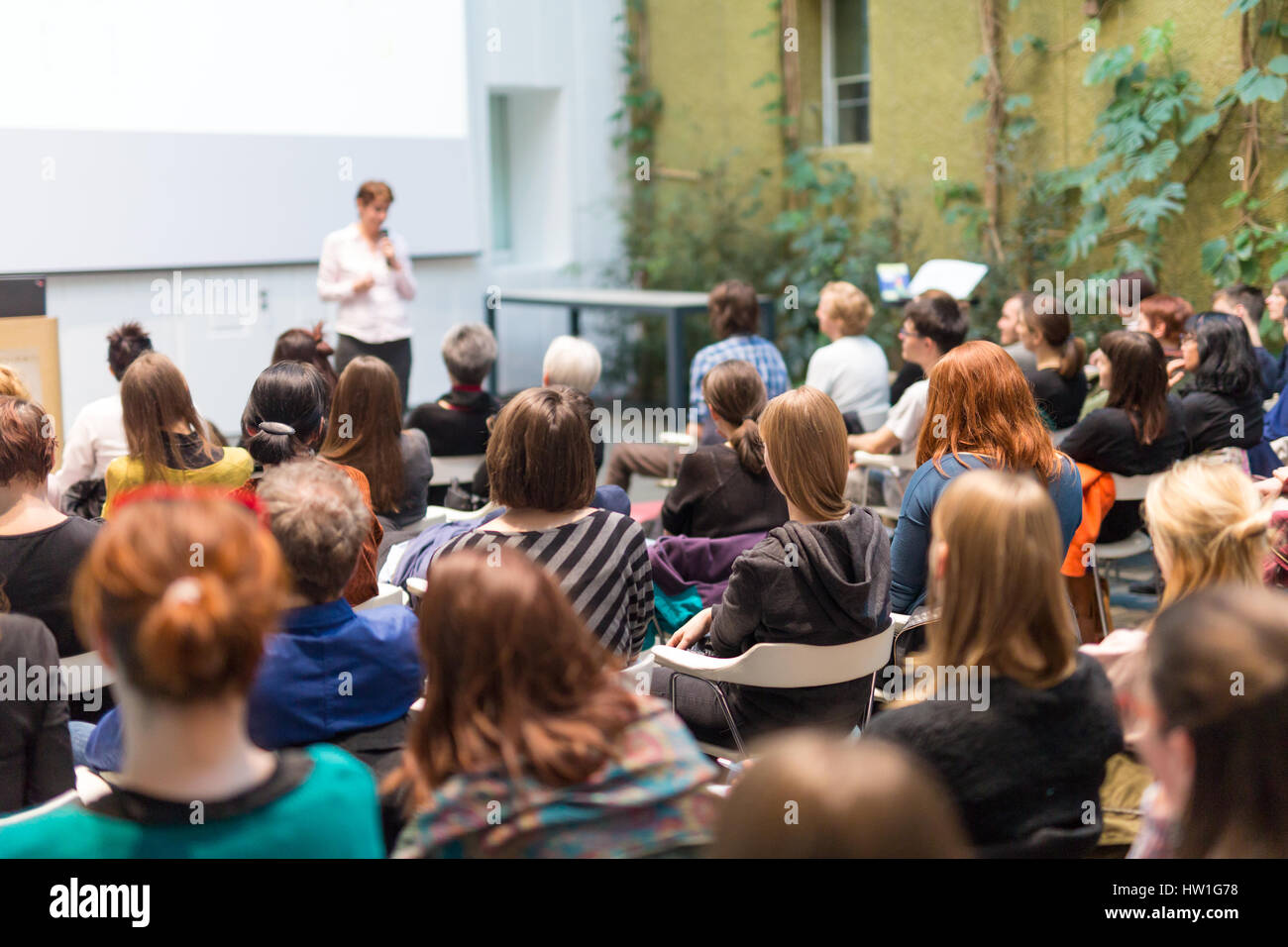 Woman giving presentation in lecture hall at university Stock Photo - Alamy