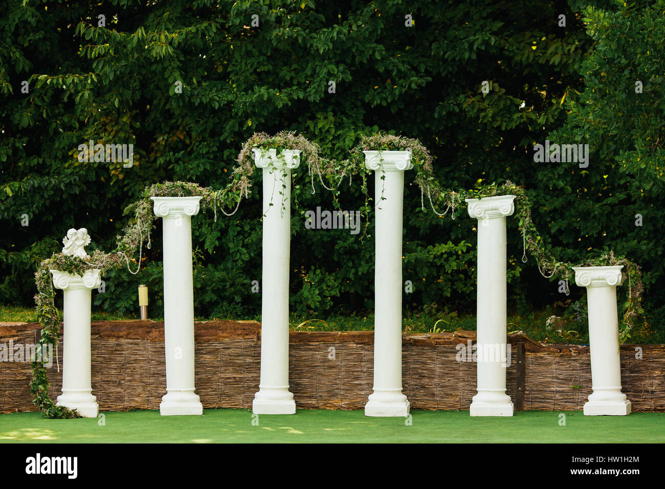 Decorated columns ahead of trees Stock Photo - Alamy