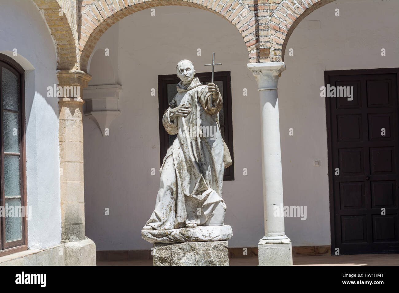 Cartuja monastery courtyard with sculpture of a saint in the center ...