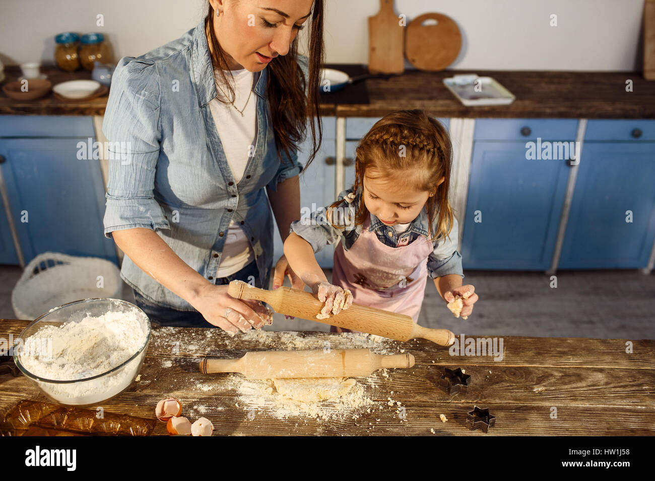 Mother explaining how to use rolling pin making bakery Stock Photo - Alamy
