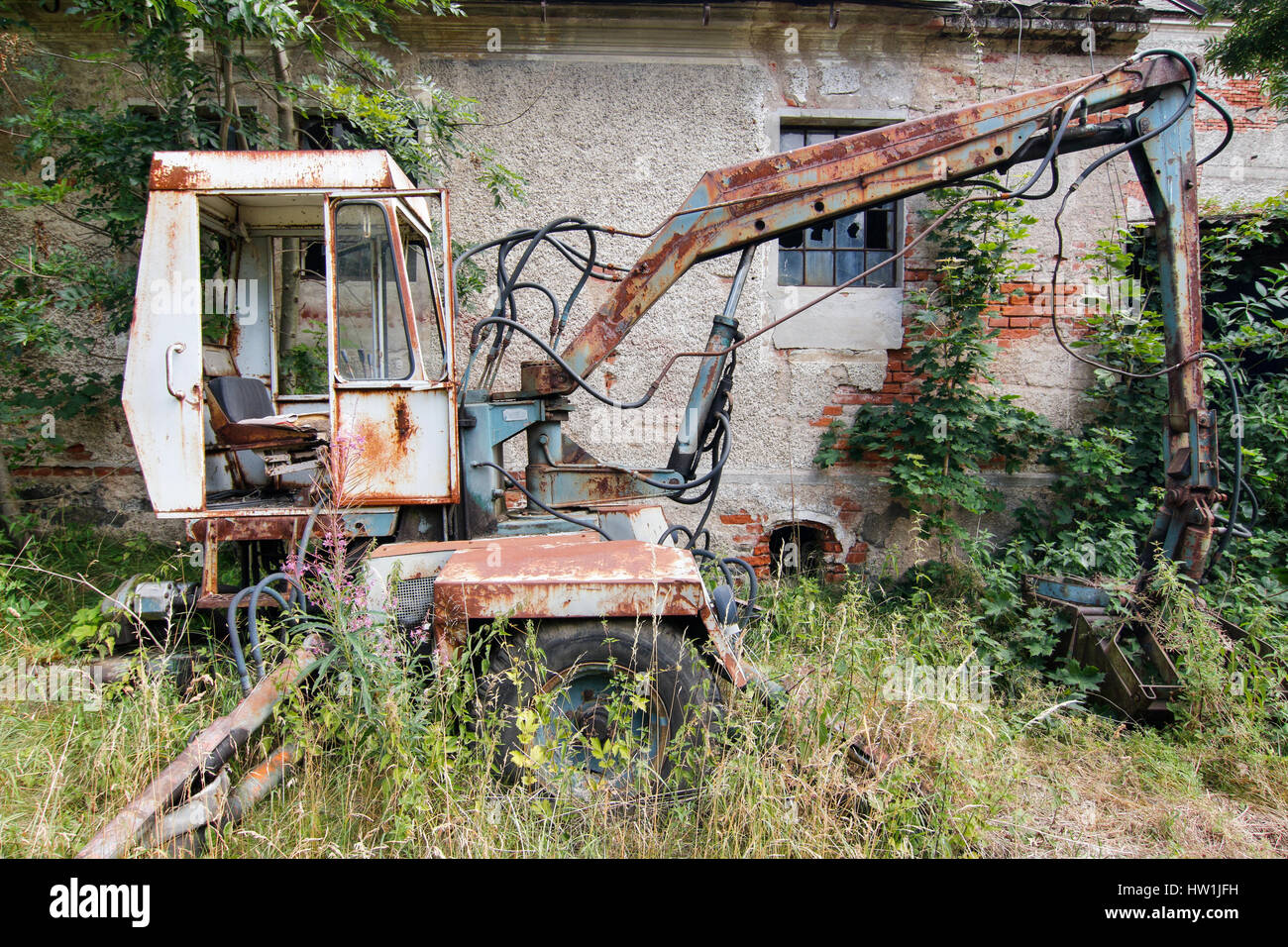 Old deserted and broken digger overgrown with grass Stock Photo - Alamy