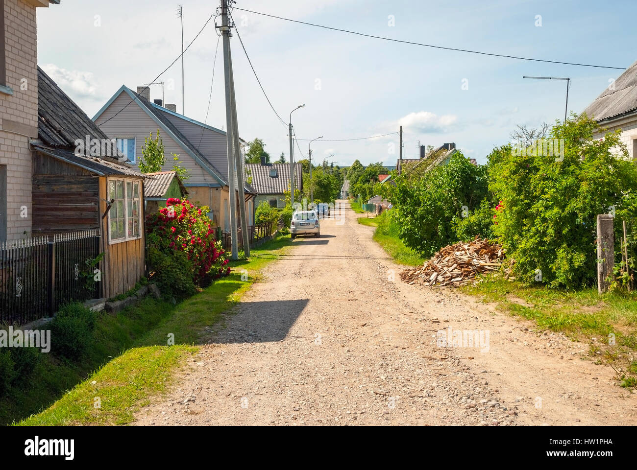 Unpaved road surrounded by rural houses in Siauliai village, Lithuania ...