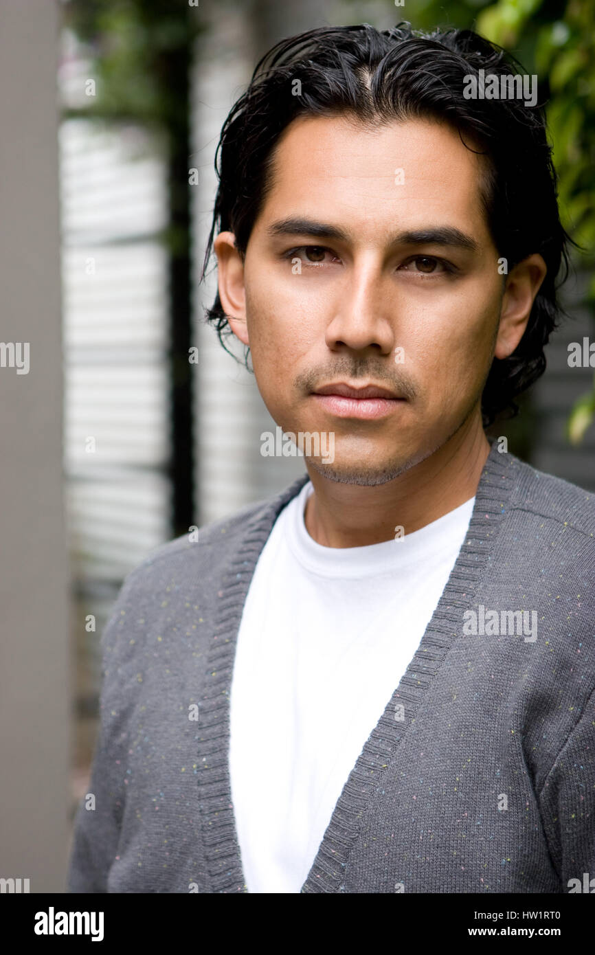 Confident Hispanic man smiling and standing outside Stock Photo - Alamy