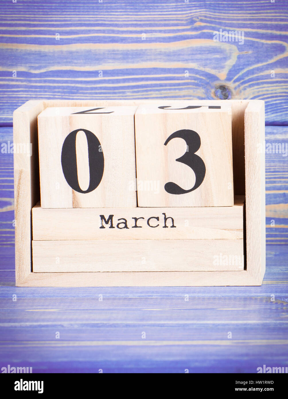 March 3rd. Date of 3 March on wooden cube calendar, purple board as ...