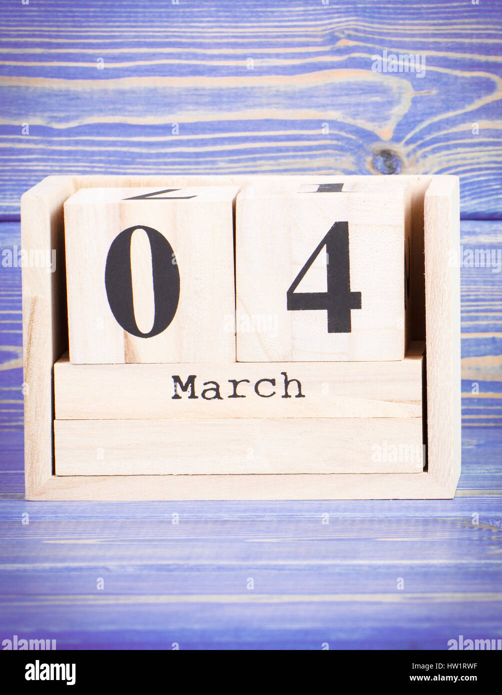 March 4th. Date of 4 March on wooden cube calendar, purple board as ...