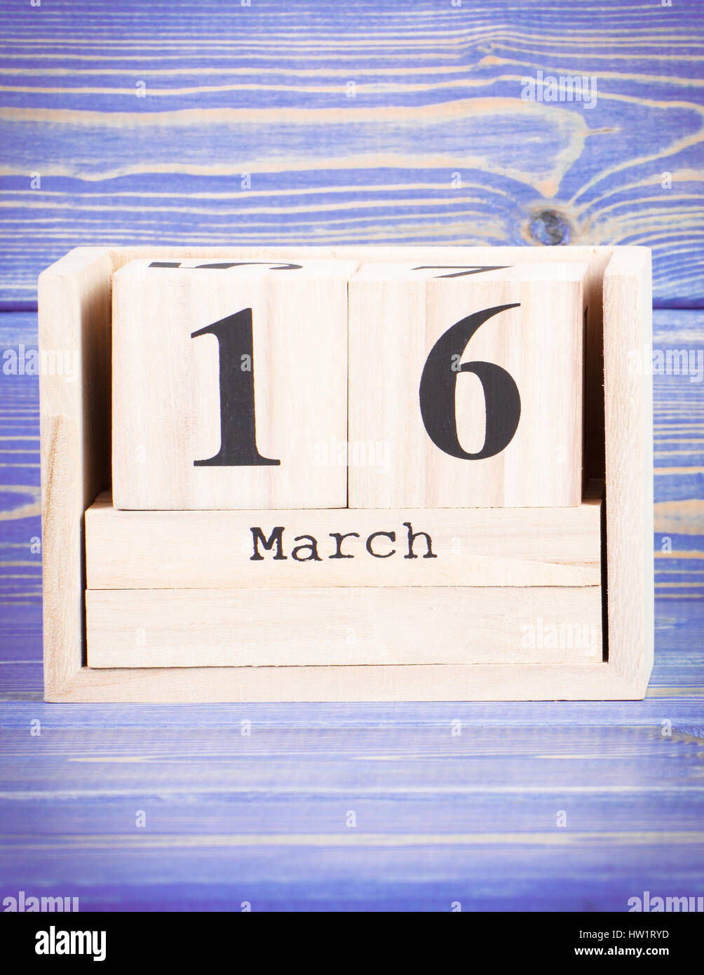 March 16th. Date of 16 March on wooden cube calendar, purple board as ...