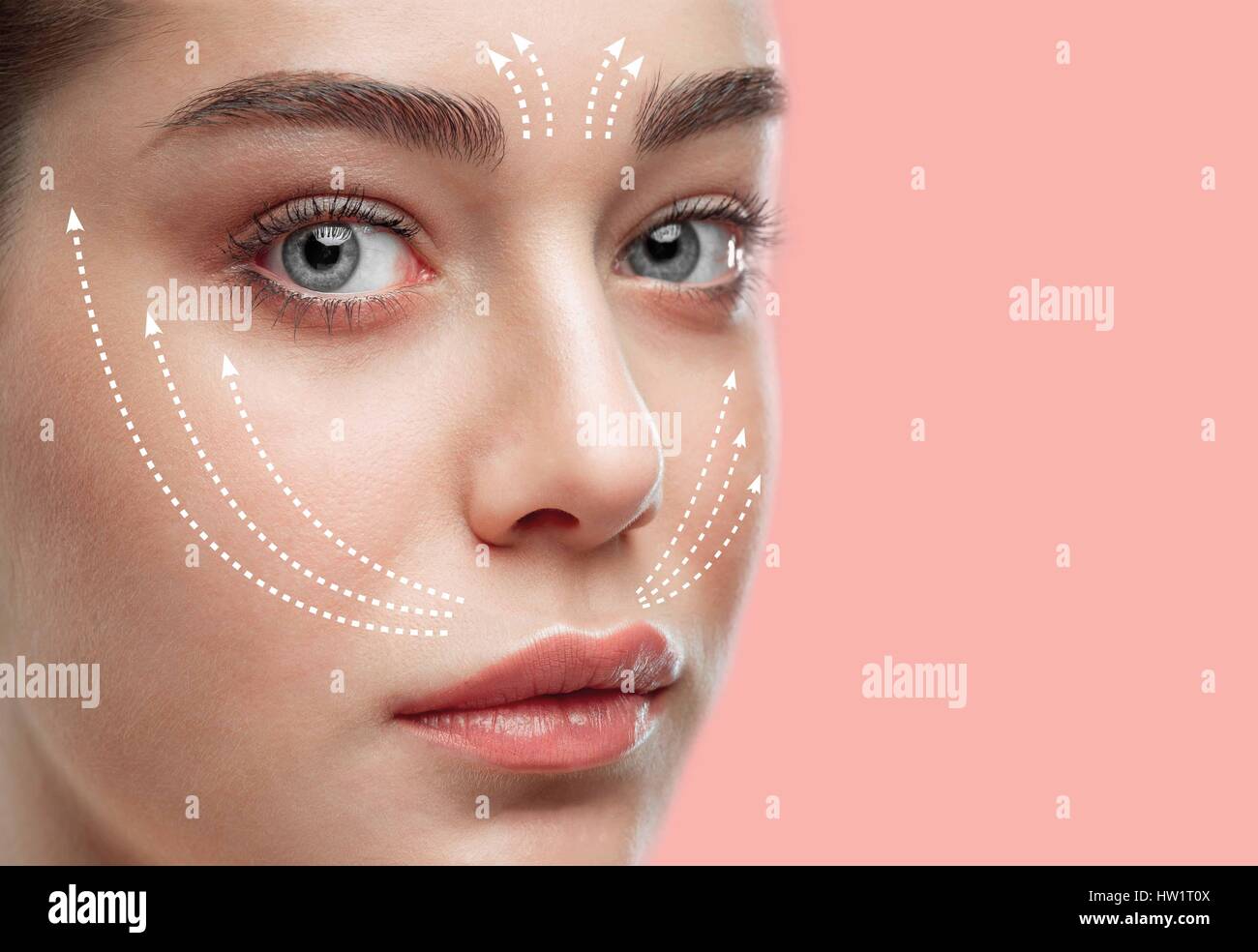 Beautiful young woman with arrows on face. Plastic surgery concept ...