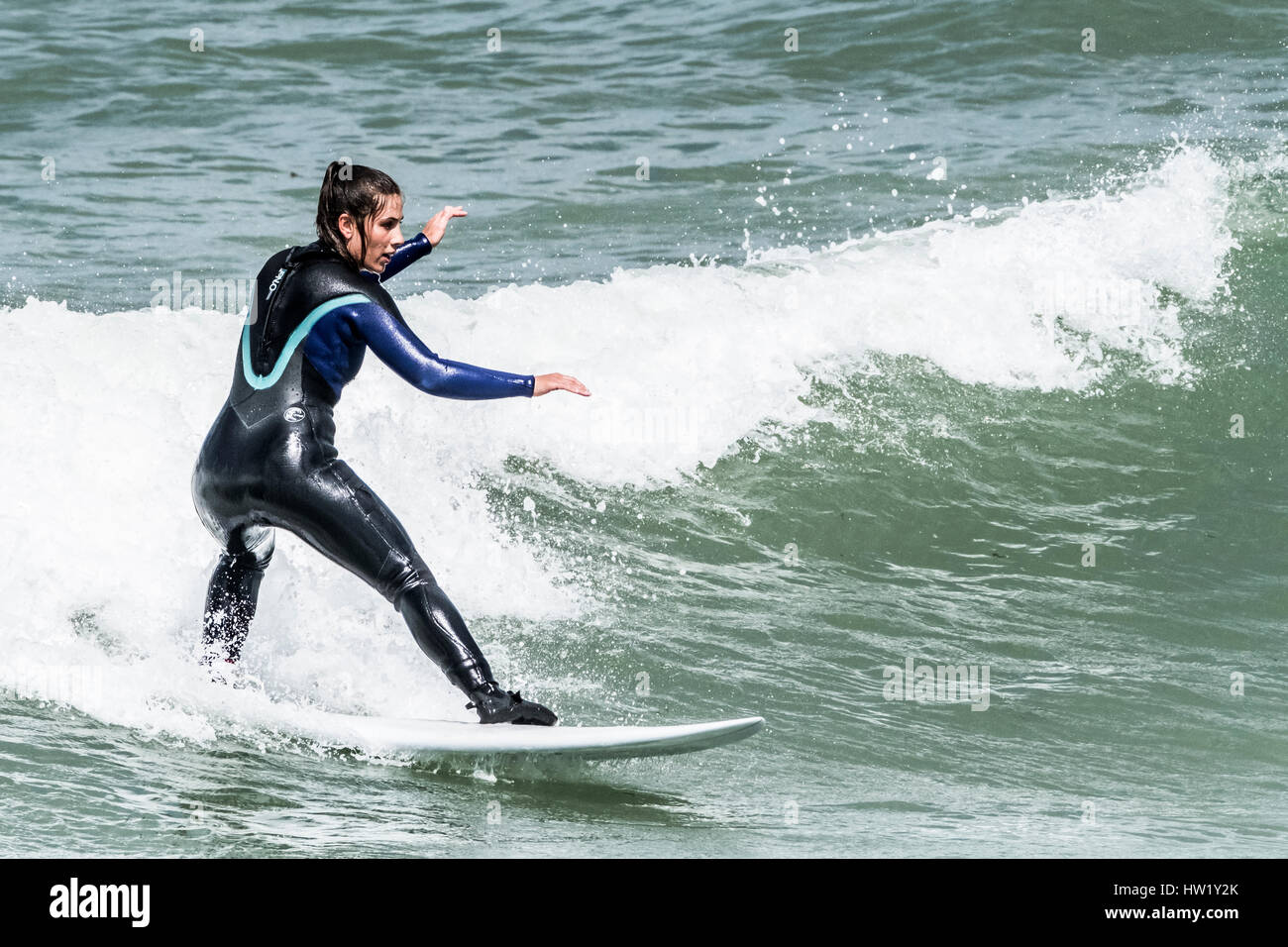 A woman surfing in Klitmoller which is a popular surfing destination in ...