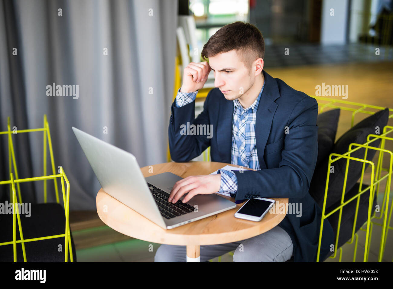 Tensed Young Man Working on Laptop at Cafe Table Stock Photo - Alamy