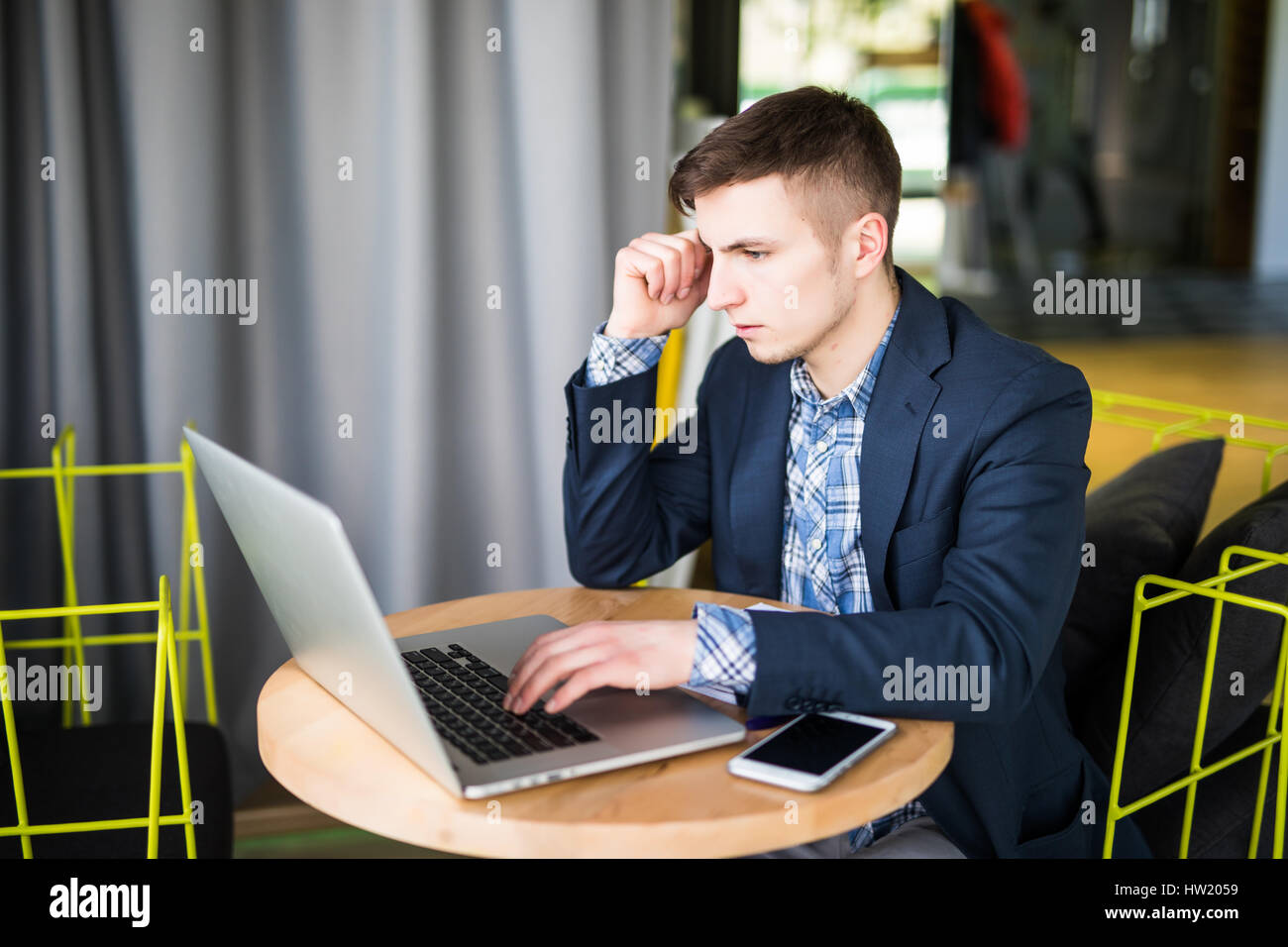 Tensed Young Man Working on Laptop at Cafe Table Stock Photo - Alamy