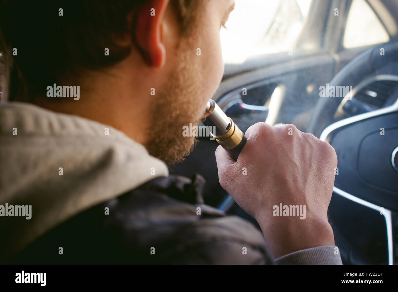 young vaper man with beard vaping mechanical mod. Guy smokes an ...