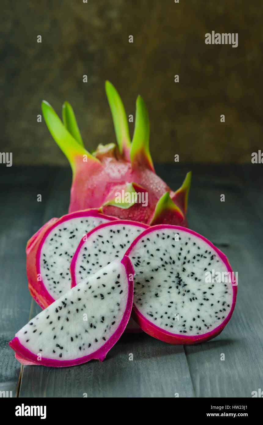 Ripe Dragon fruit or Pitaya with slice on wooden background , still ...